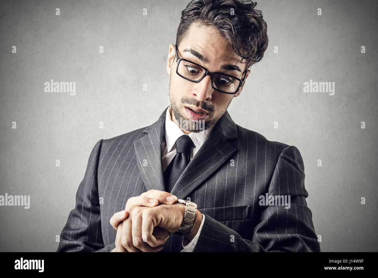 Businessman looking at watch Stock Photo - Alamy