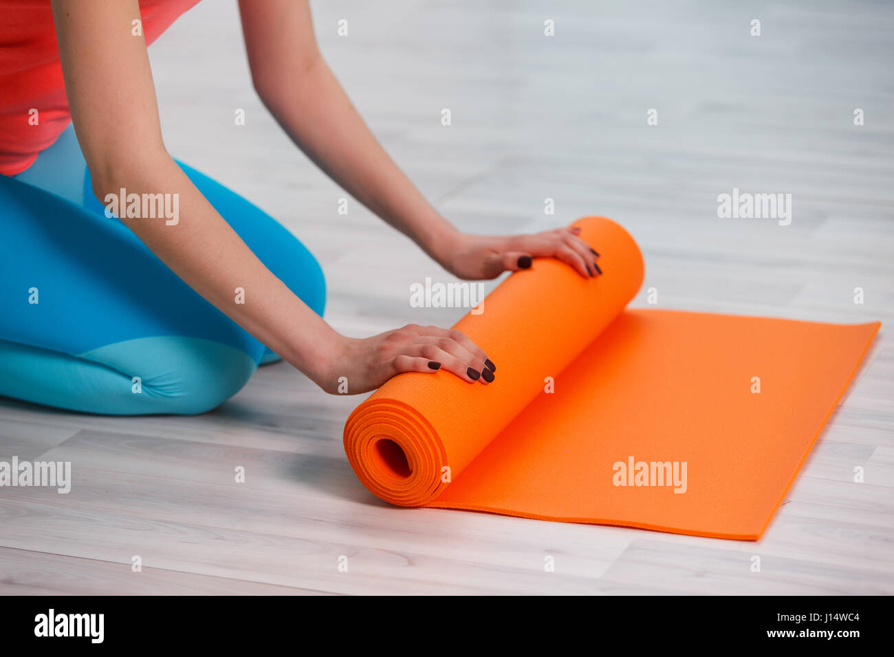 Young athlete rolls sports mat Stock Photo - Alamy
