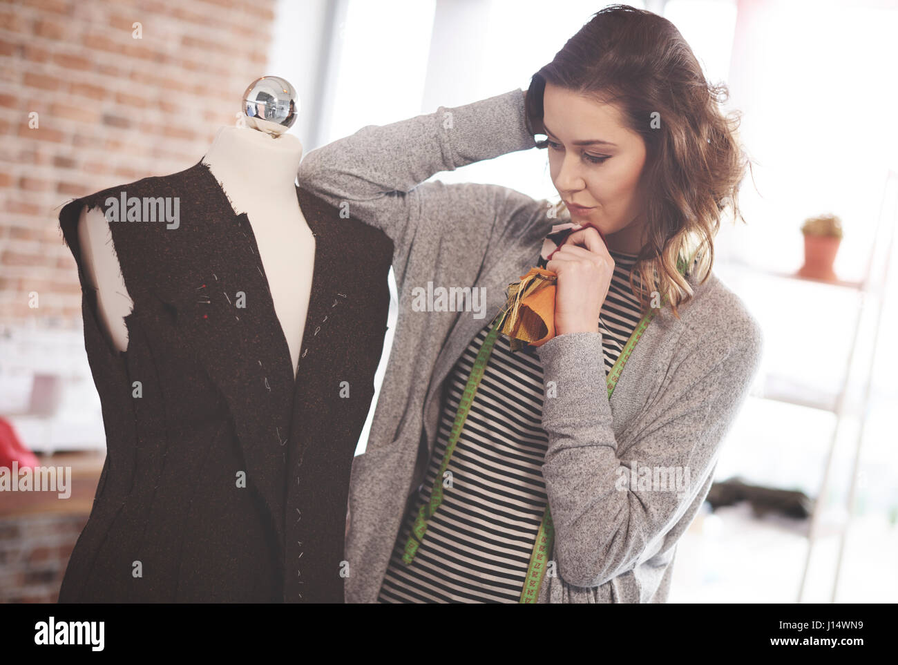 Female fashion designer thinking about changes Stock Photo - Alamy