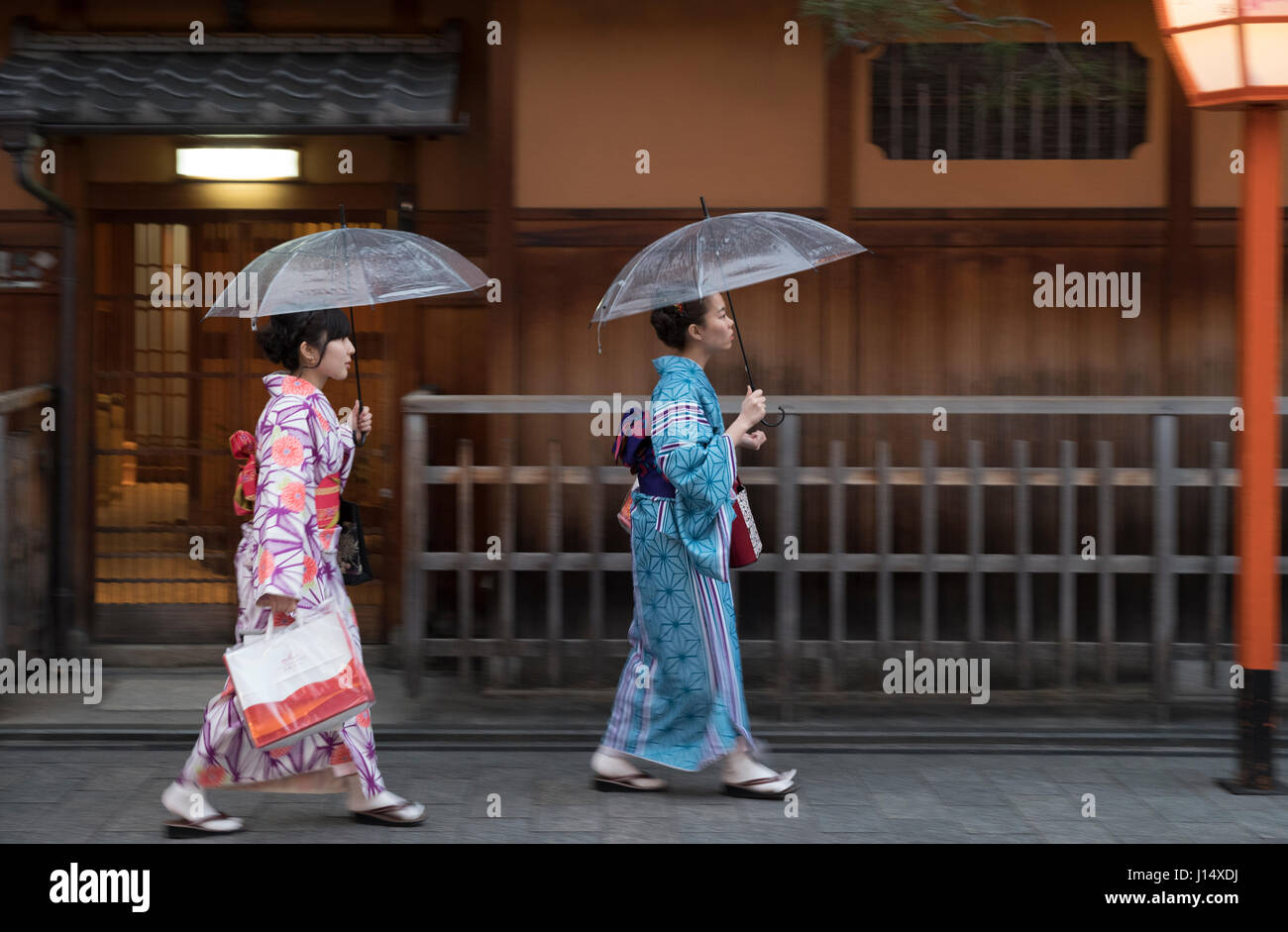 Young Japanese women in kimonos brave the rain in Hanami-koji Street ...