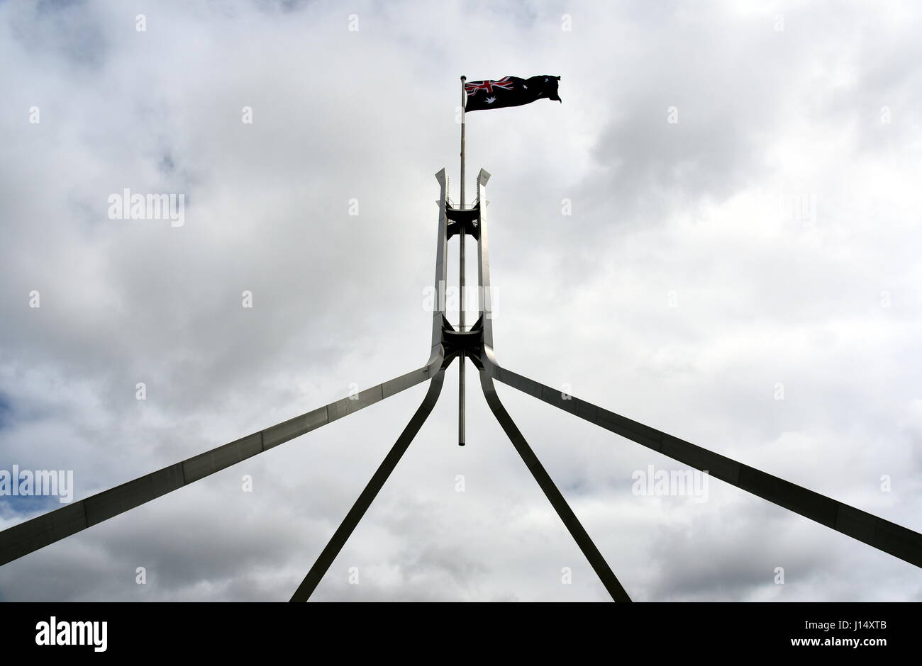 The Australian flag flying on top of Parliament House with cloudy sky ...