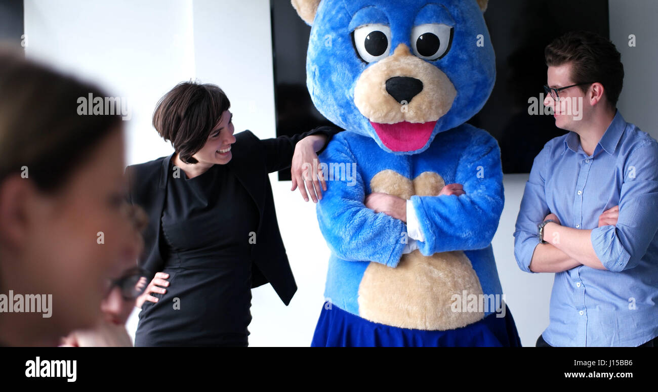 Boss dresed as teddy bear having fun with bussines people in modern ...