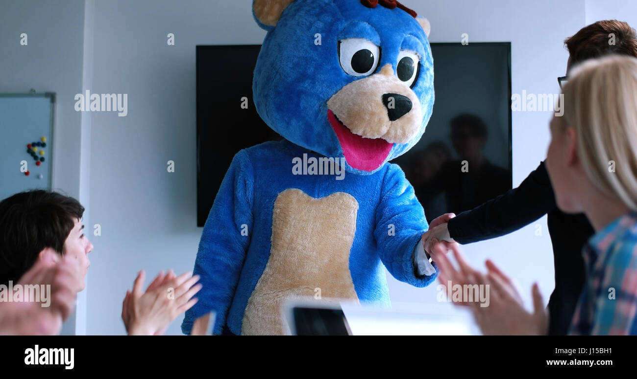 Boss dresed as teddy bear having fun with bussines people in modern ...