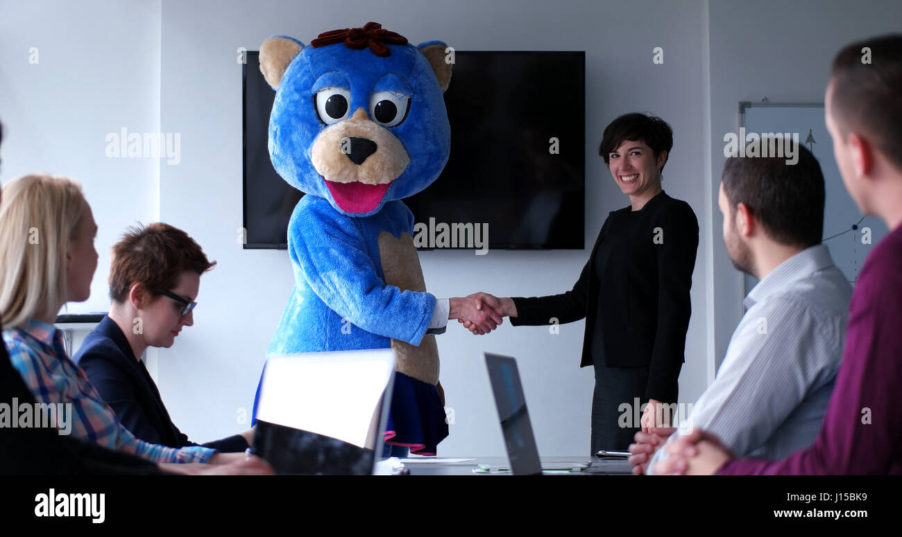 Boss dresed as teddy bear having fun with bussines people in modern ...