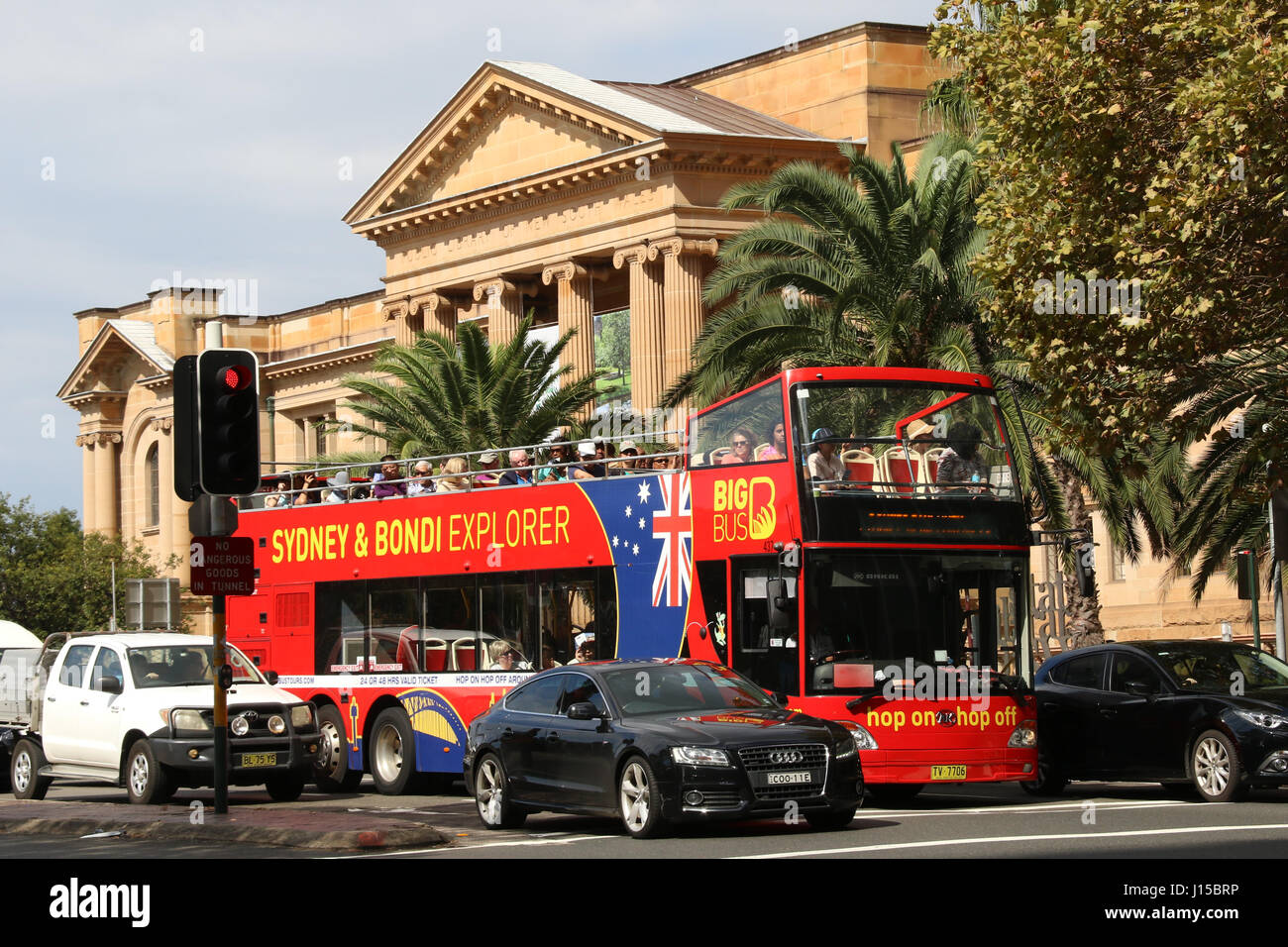 A red Sydney & Bondi Explorer Bus passes by the State Library of NSW ...