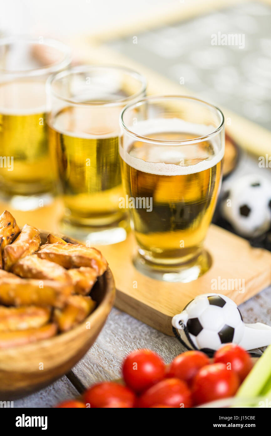 Draft beer and salty snacks on the table for soccer party Stock Photo ...