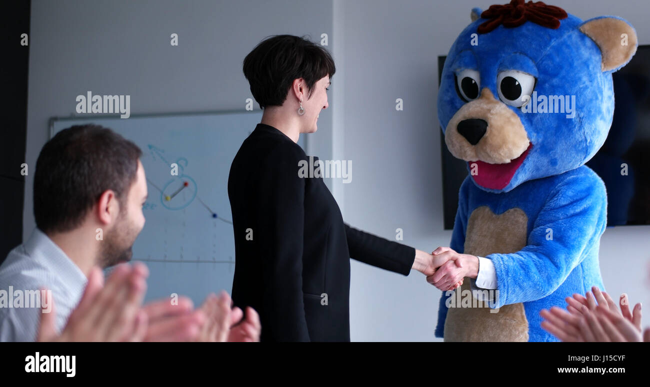 Boss dresed as teddy bear having fun with bussines people in modern ...