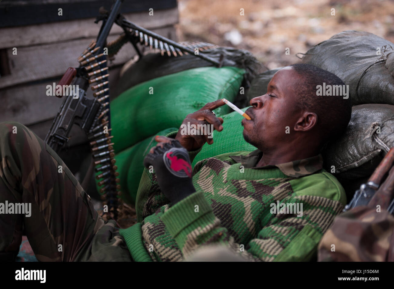 A DRC soldier has a smoke break on the frontline during operations ...