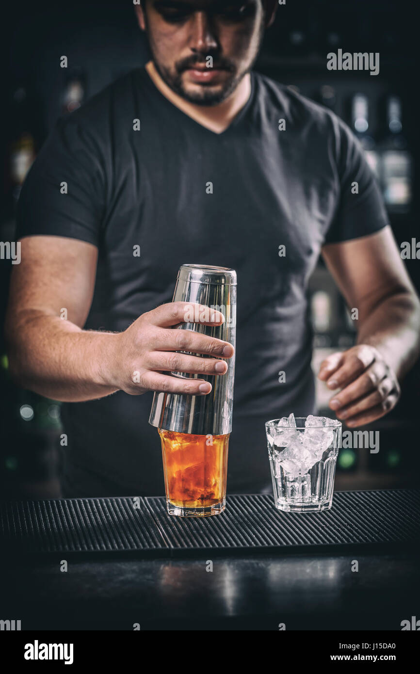Handsome young barman make cocktails with a shaker Stock Photo - Alamy