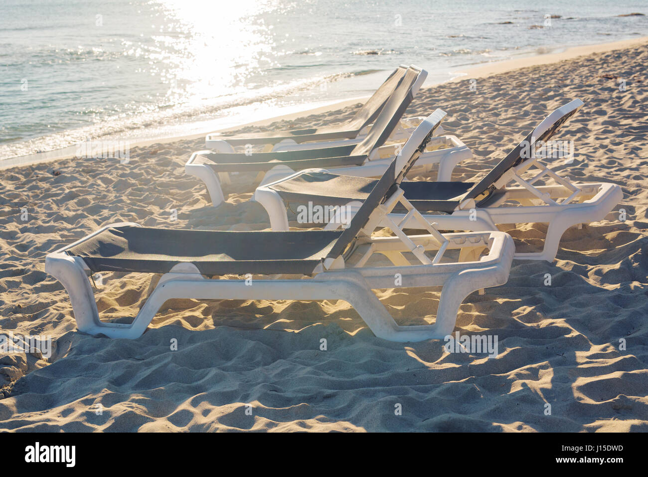 Sunbeds on the sea beach during sunset Stock Photo - Alamy