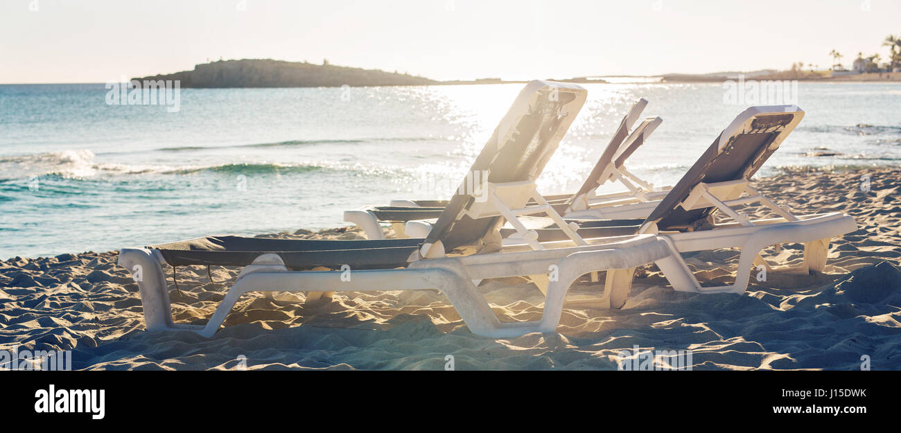 Sunbeds on the sea beach during sunset Stock Photo - Alamy