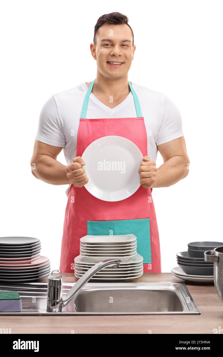 Young man in an apron showing a clean plate isolated on white ...