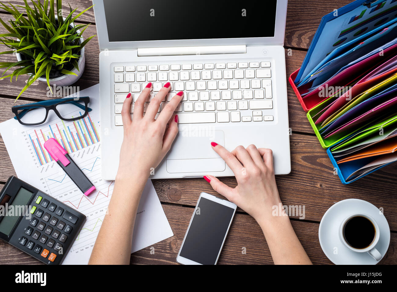 Overhead shot of office desktop with modern computer, graphs and charts ...