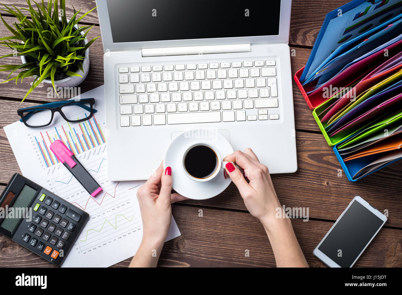 Overhead shot of office desktop with modern computer, graphs and charts ...
