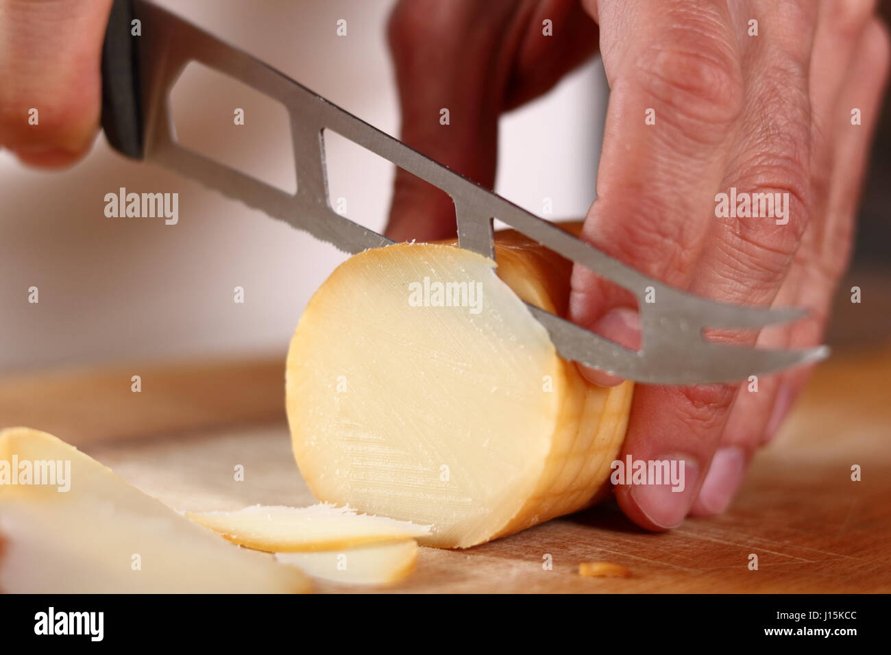 Slicing smoked cheese Stock Photo - Alamy