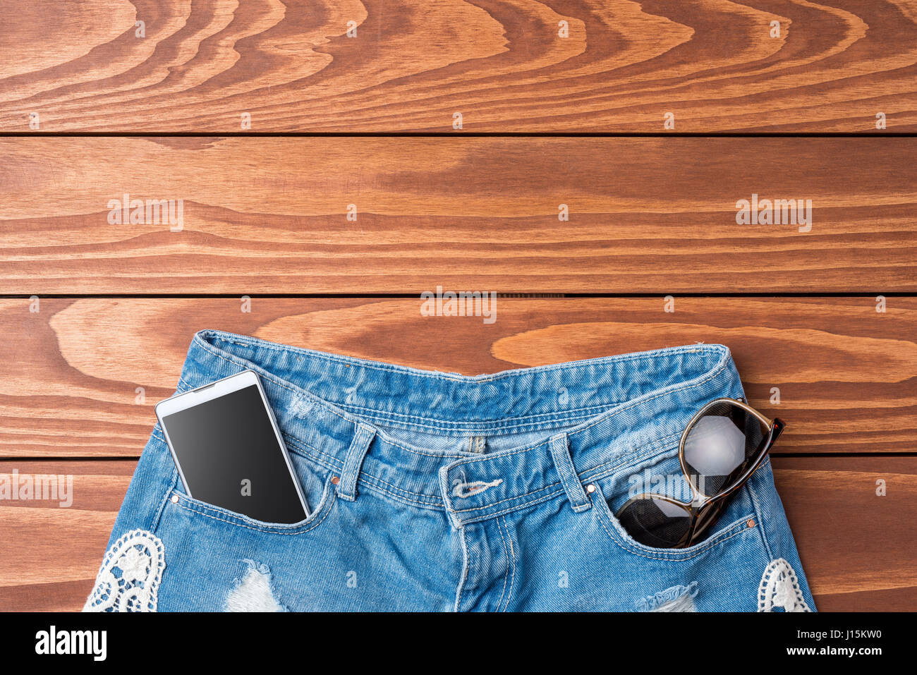 Woman's jeans shorts on wooden table Stock Photo - Alamy
