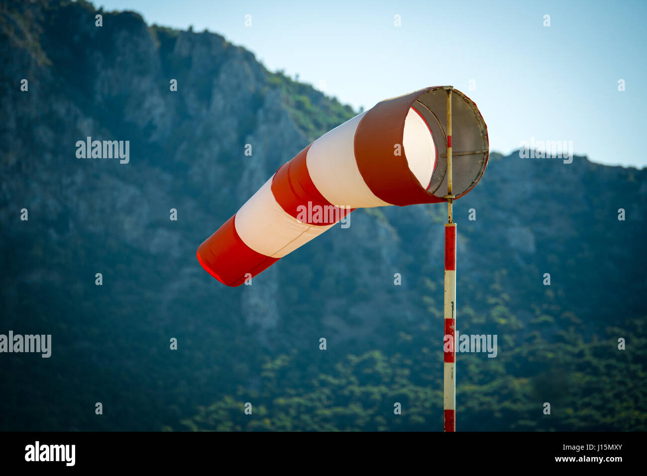 Horizontally flying windsock (wind vane) due to high wind. Blue sky and ...
