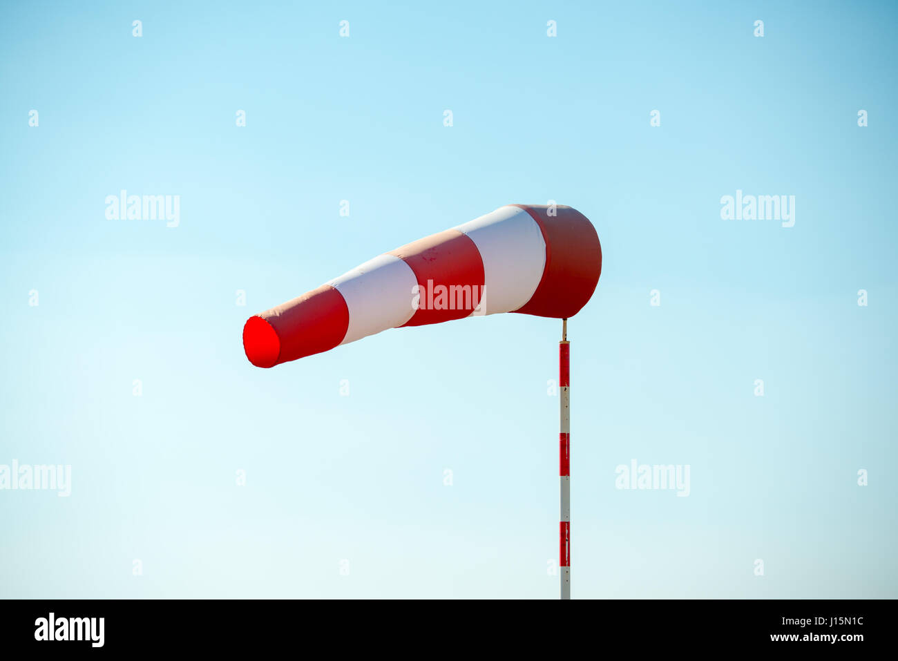 Horizontally flying windsock (wind vane) due to high wind. Blue sky in ...