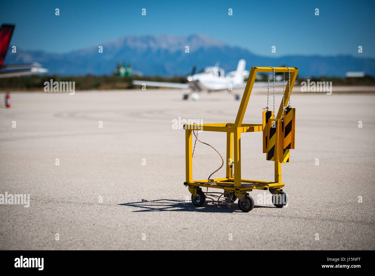 A yellow aircraft chocks and fire extinguisher carrier on a small ...