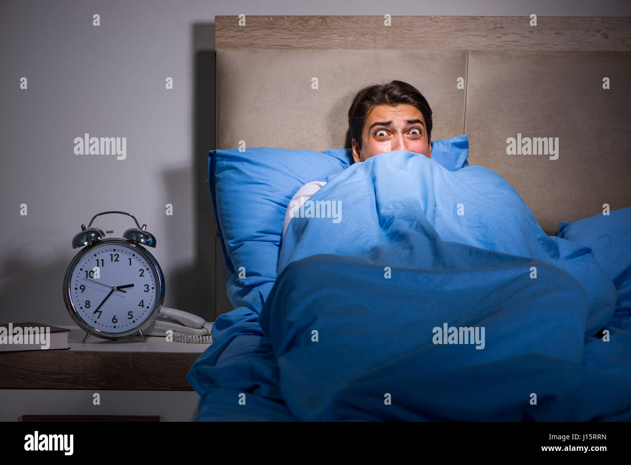 Young man scared in bed Stock Photo - Alamy