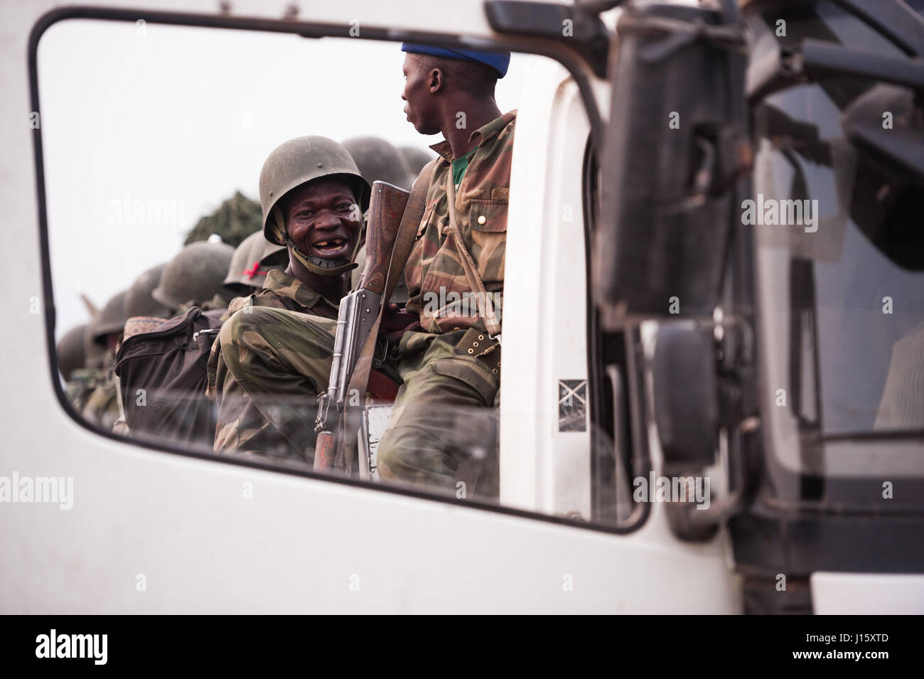 A DRC national army (FARDC) soldier reflected in the mirror of a truck ...