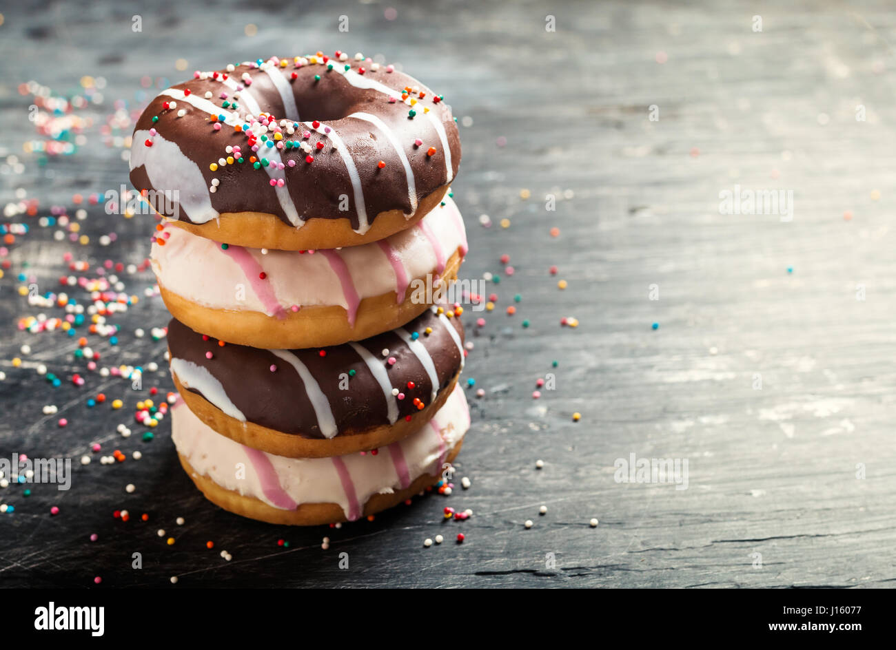 Stack of delicious donuts on black background Stock Photo - Alamy