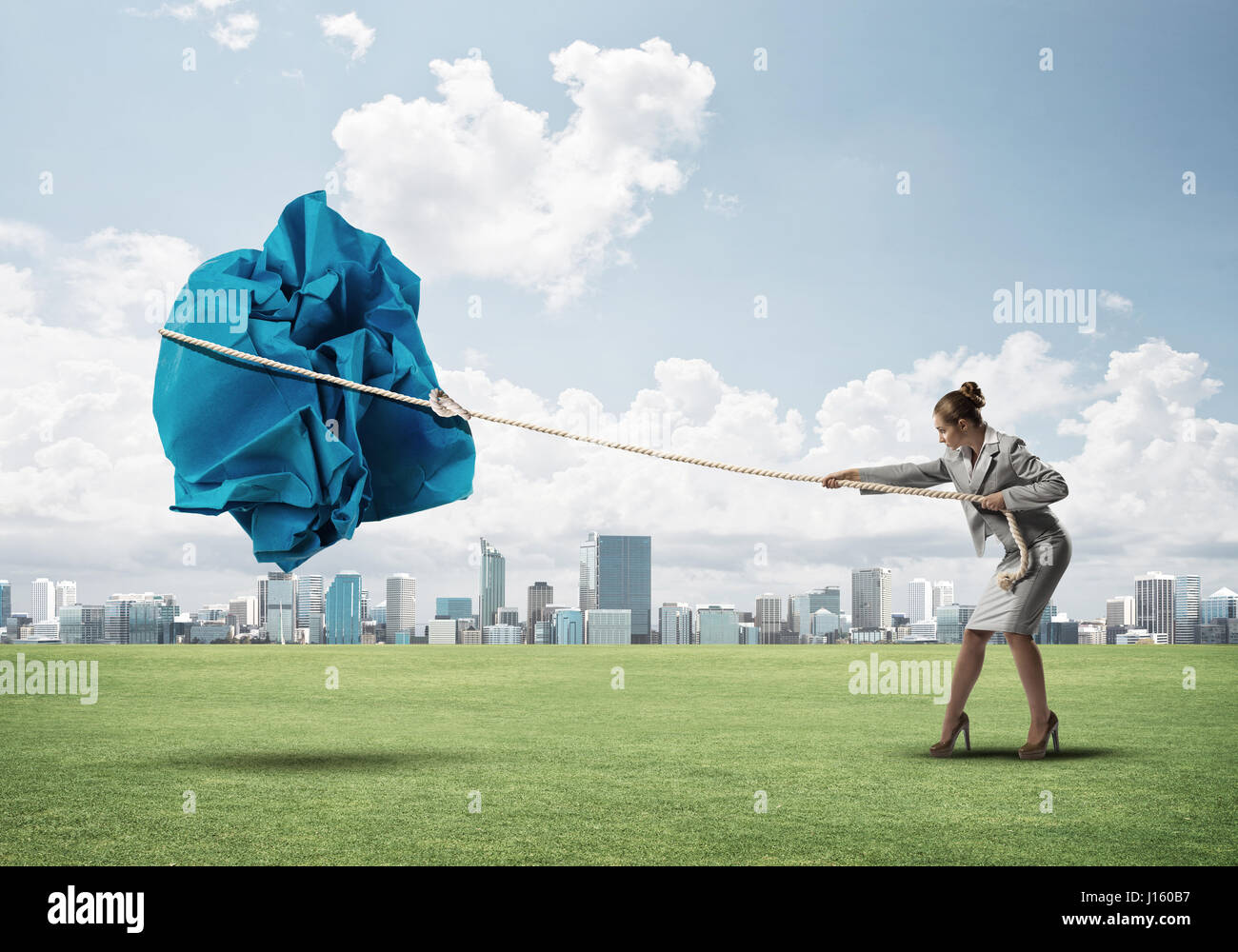Woman pulling with effort big crumpled ball of paper as creativity sign ...