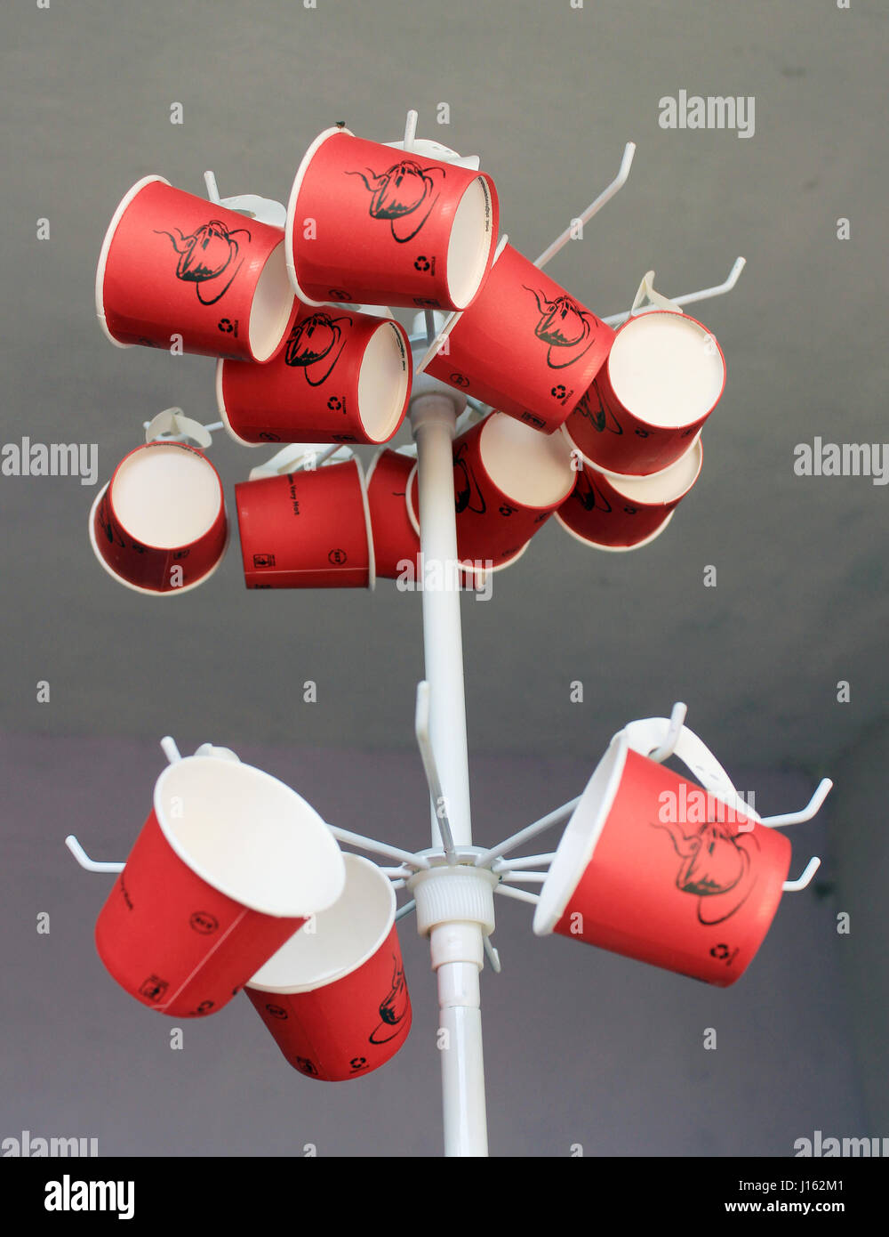 Modern colorful cups hanging on the iron stand Stock Photo - Alamy