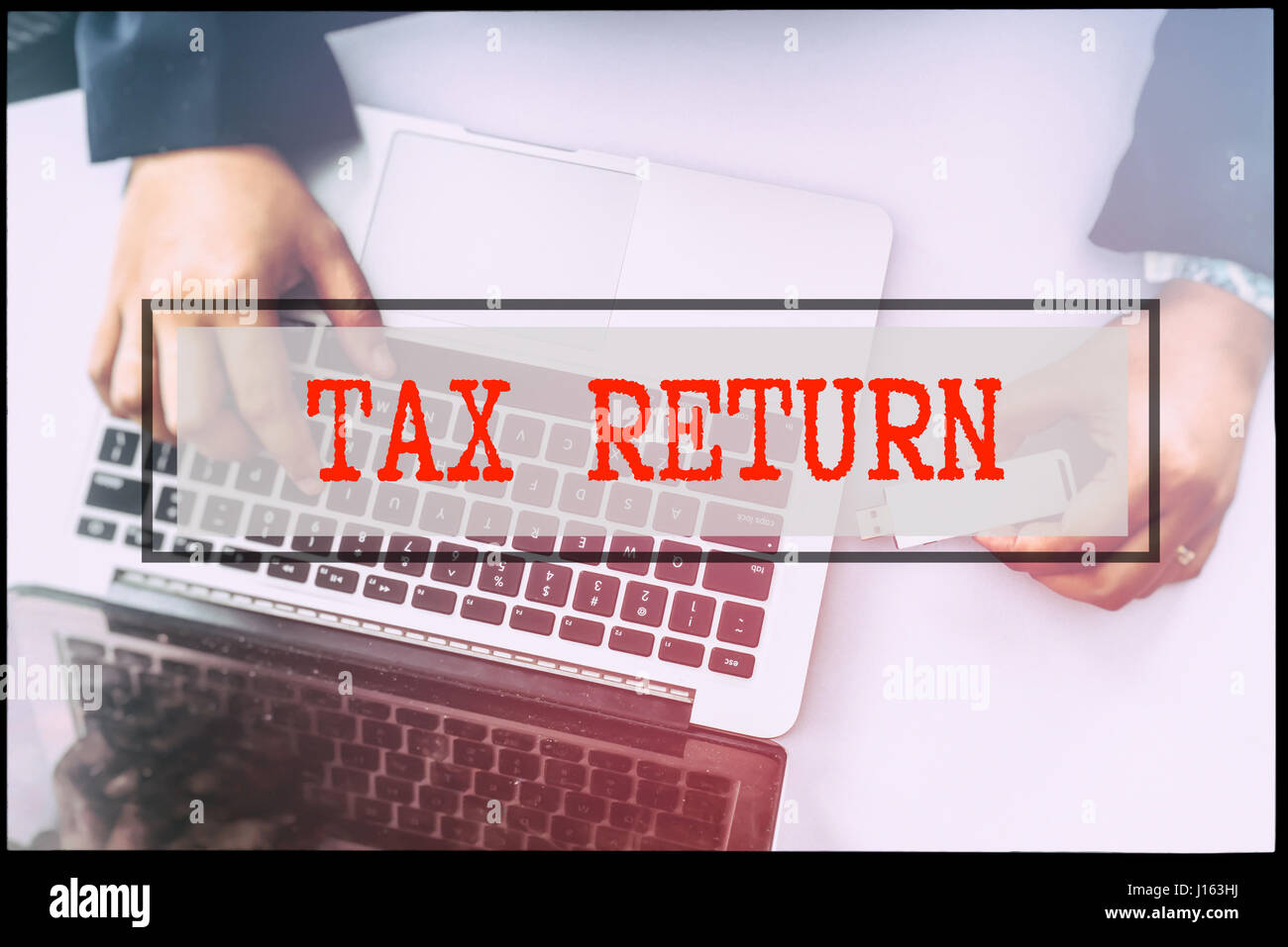 Hand and text TAX RETURN with vintage backgound. Technology concept ...