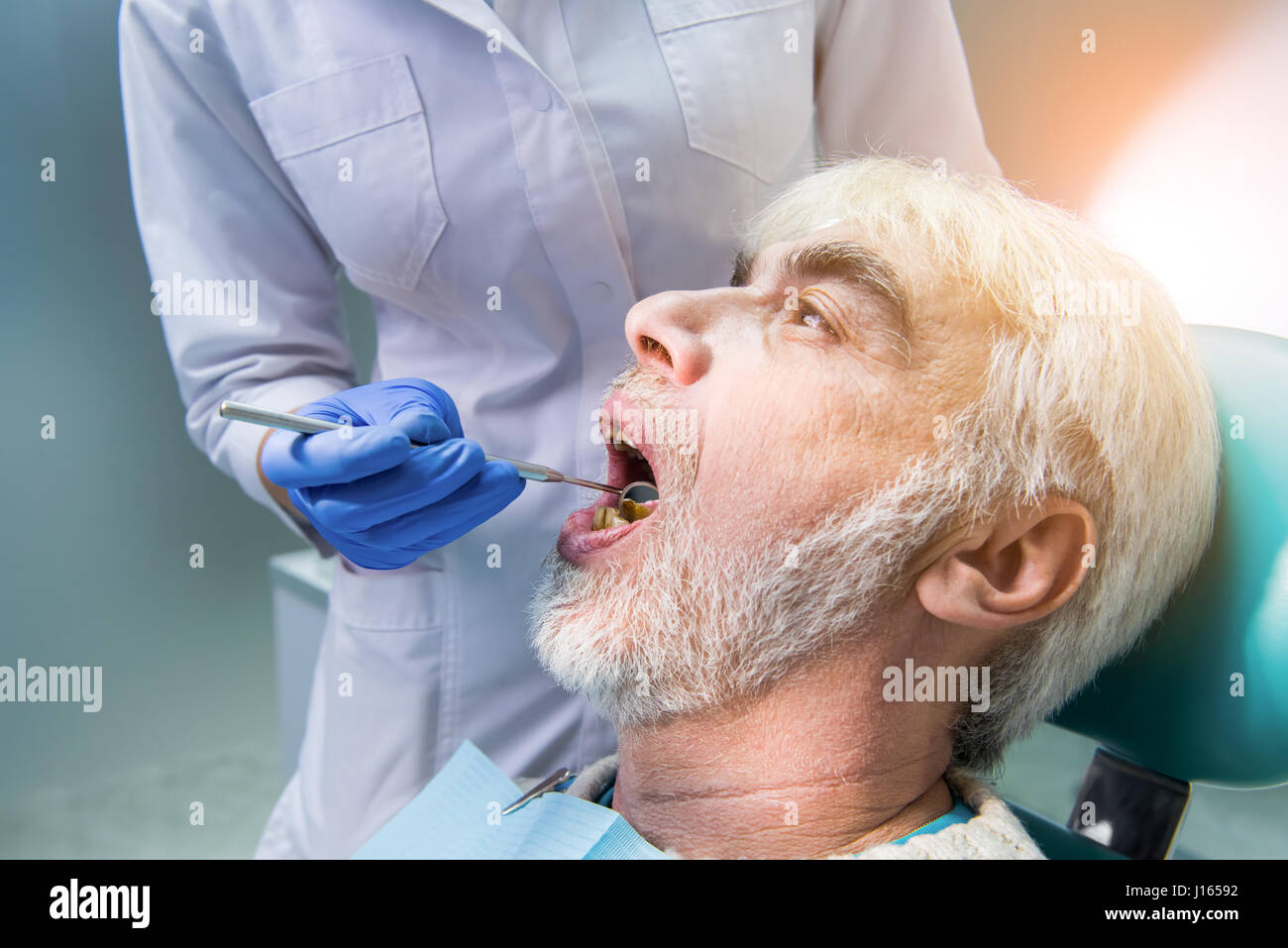 Dentist with mirror examining patient. Man with bad teeth. Benefits of ...