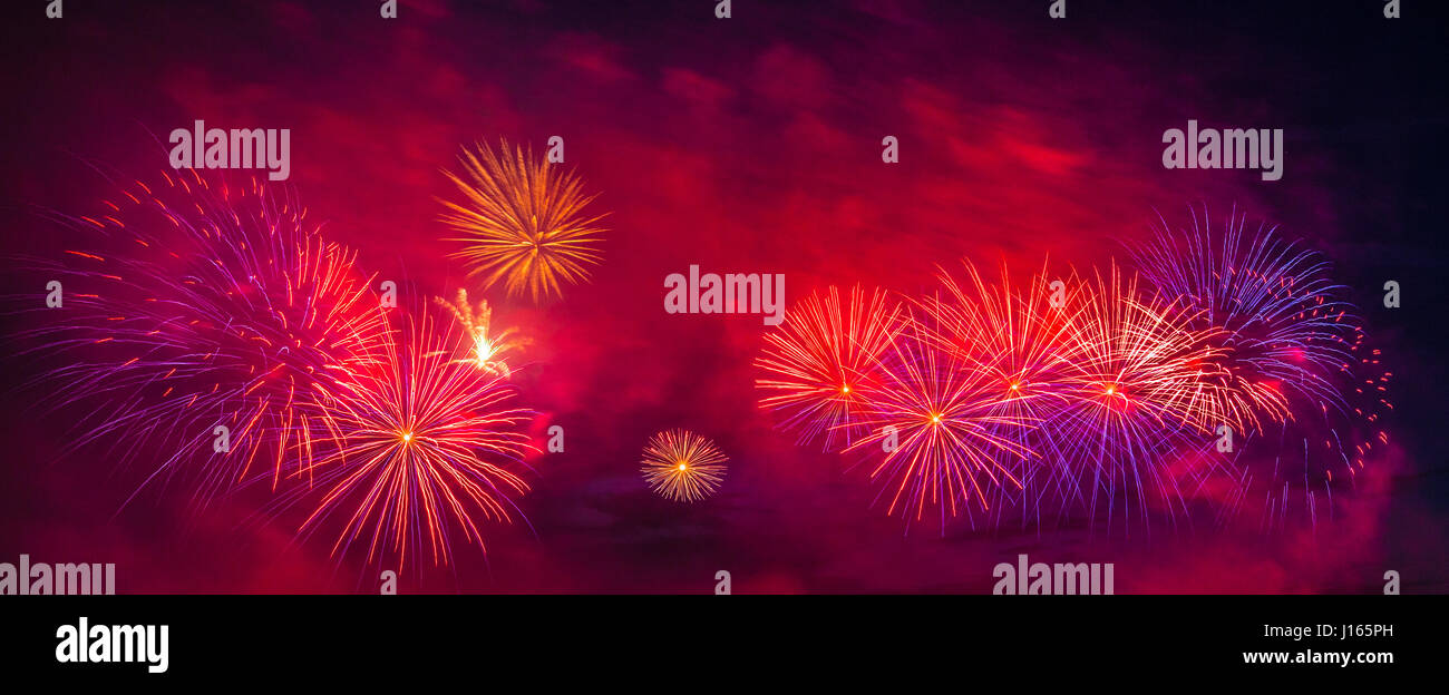 Multicolor fireworks with cityscape at night time Stock Photo - Alamy