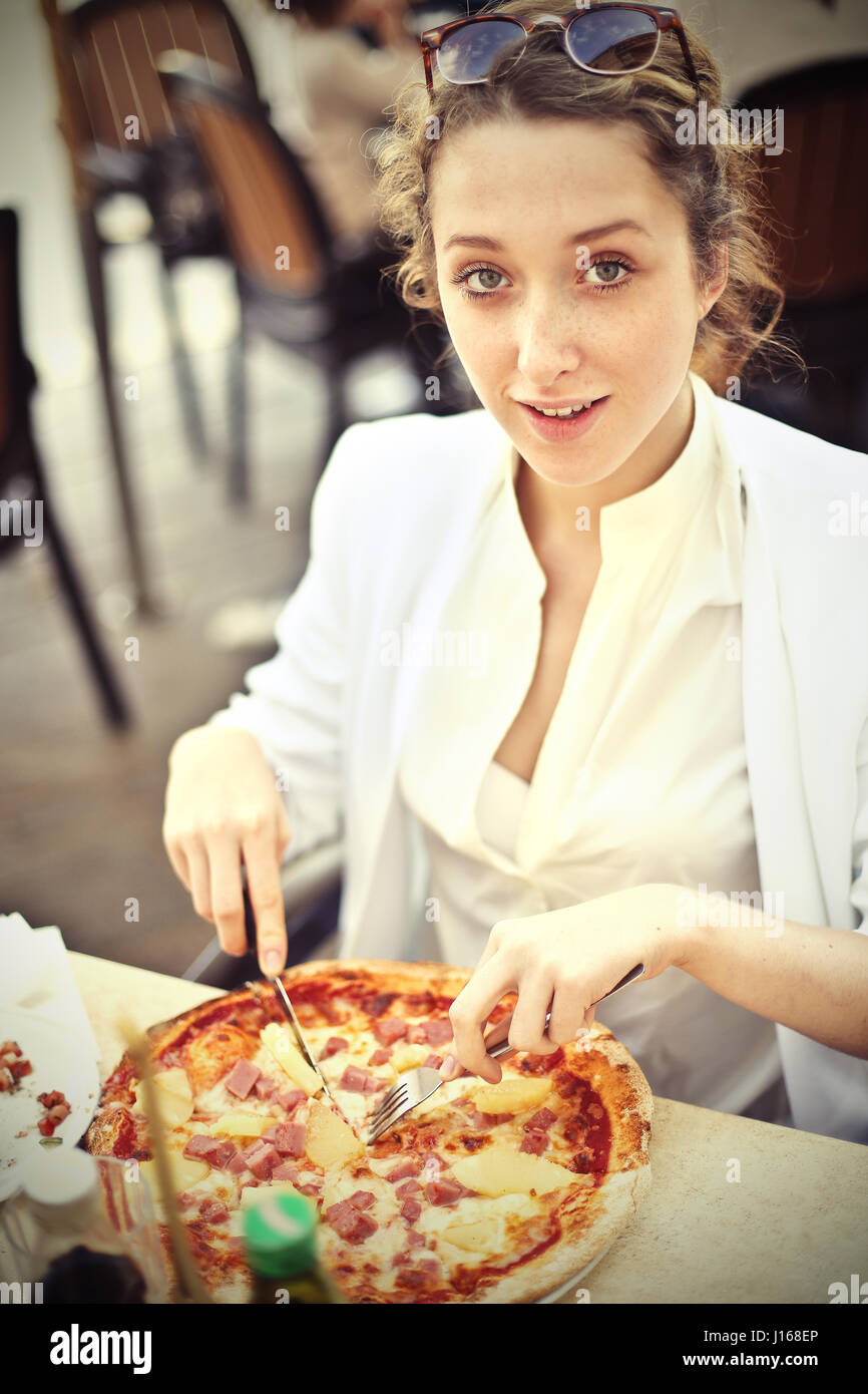 Brunette woman eating pizza Stock Photo - Alamy