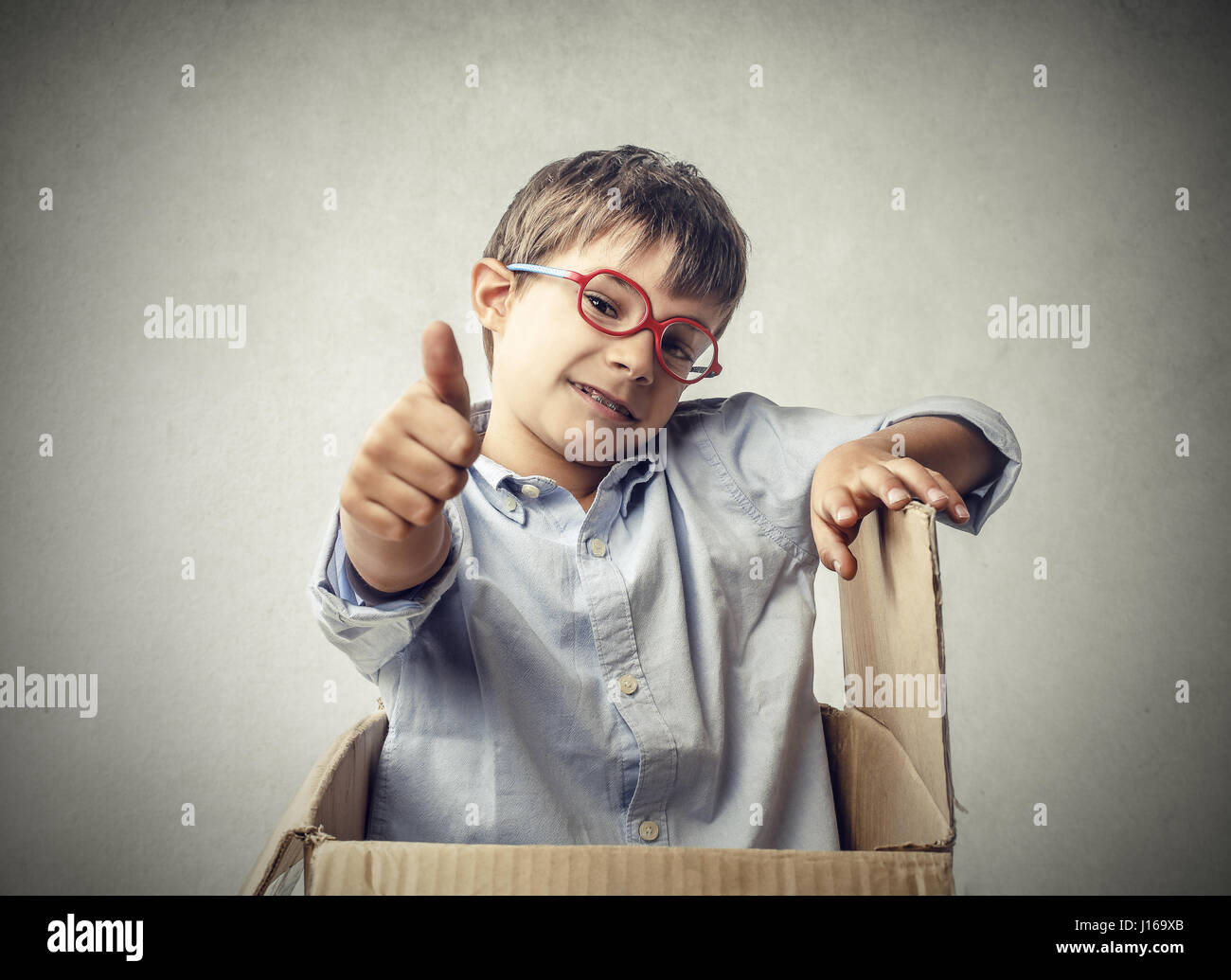 Little boy sitting in box Stock Photo - Alamy