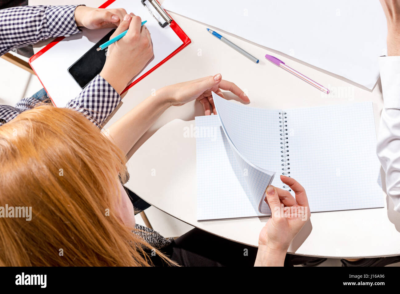 The woman sitting behind desk, checking reports, talking Stock Photo ...