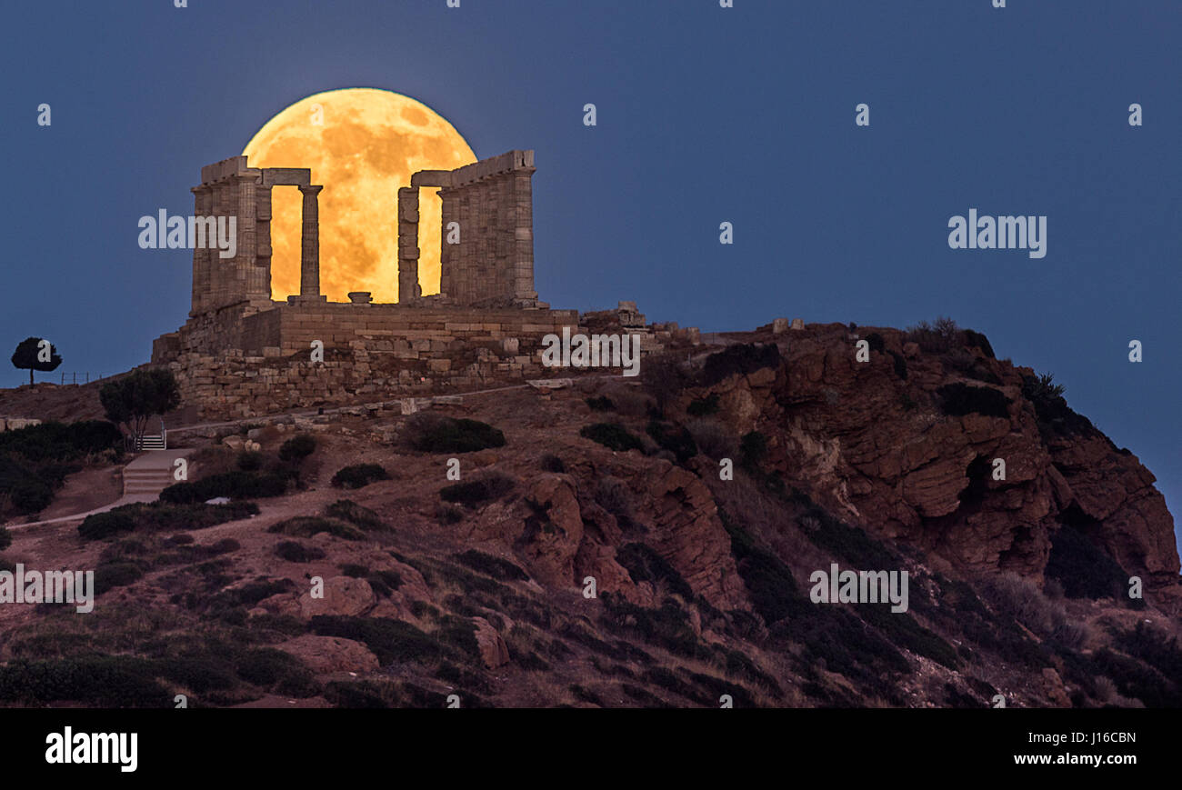 ATHENS, GREECE: A golden coloured moon rises above the famous Temple of ...