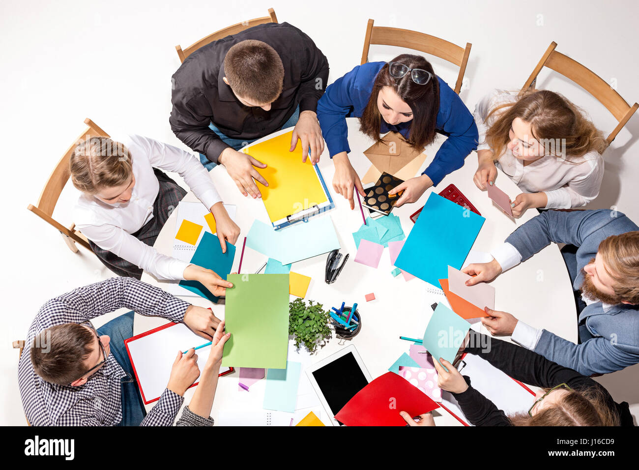 Team sitting behind desk, checking reports, talking. Top View Stock ...