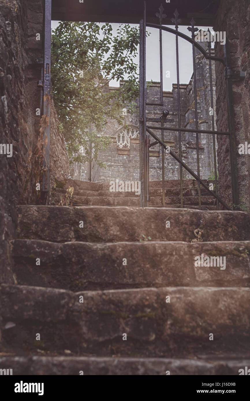 Low angle shot of old stone steps to a gate opening to a church ...