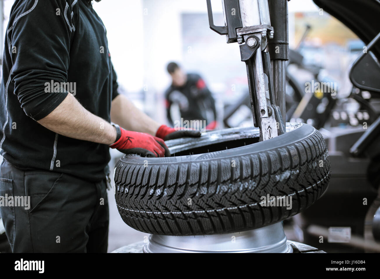 Man working on tire Stock Photo - Alamy