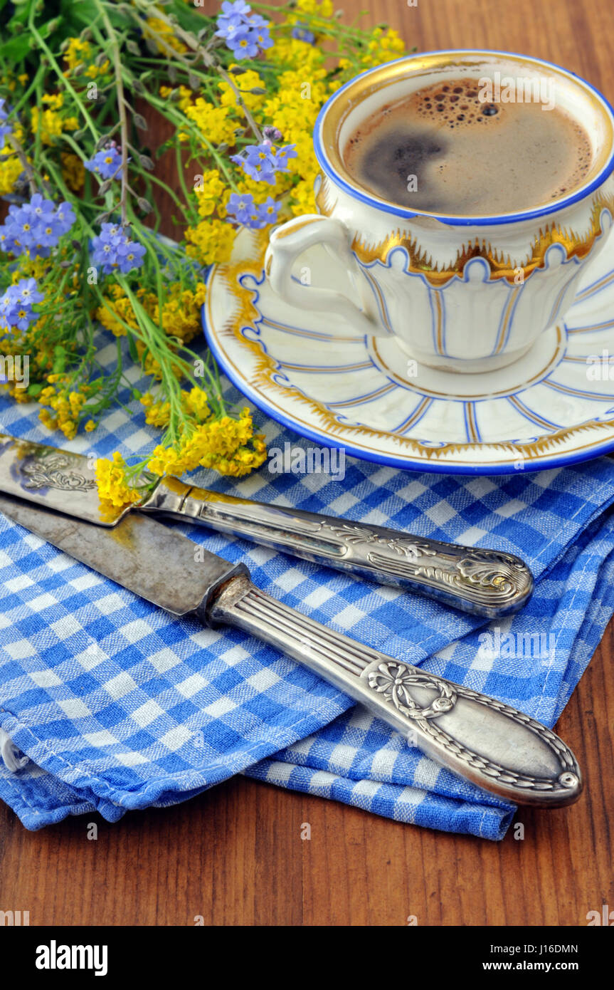 antique coffee cup with old silverware and bunch of forget me not ...