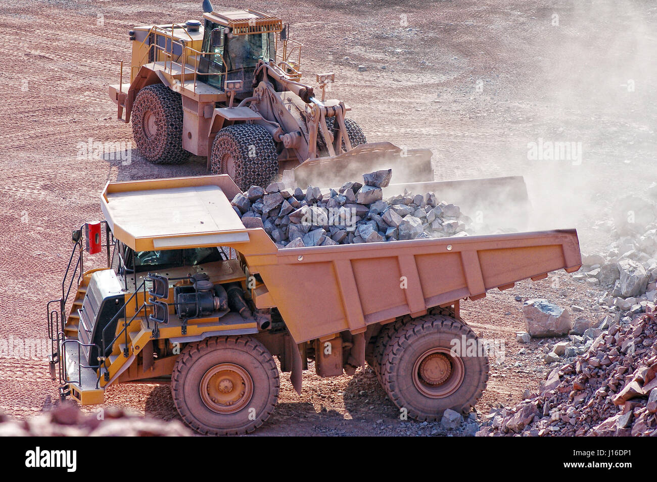 View into a quarry mine. earth mover loading dumper truck with rocks ...