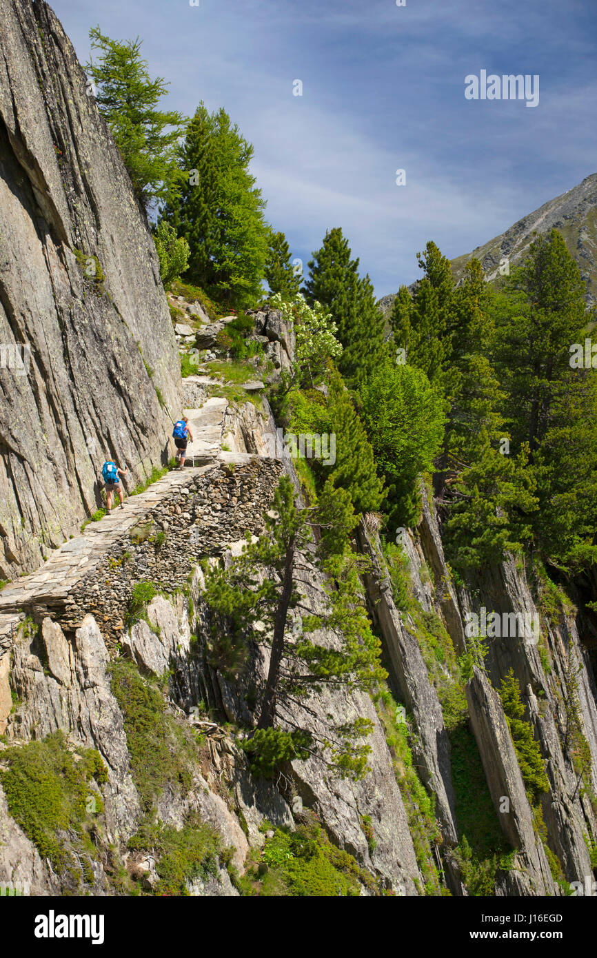 Two Hikers Walking Over A Small Mountain Trail Of Rock Stock Photo - Alamy