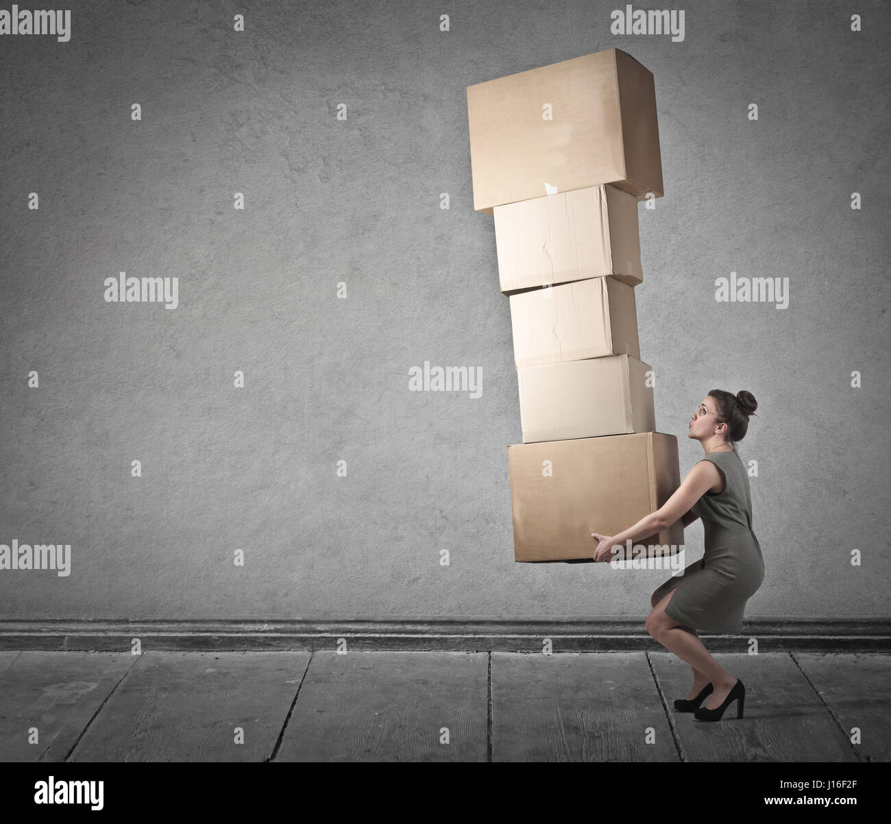 Woman carrying heavy boxes in empty room Stock Photo - Alamy