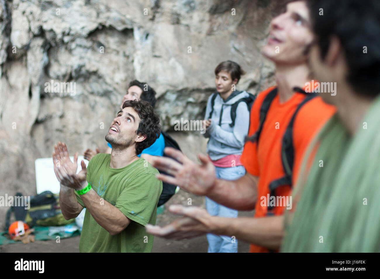 Group Of People Clapping For Another Climber Climbing Over The Rock In ...