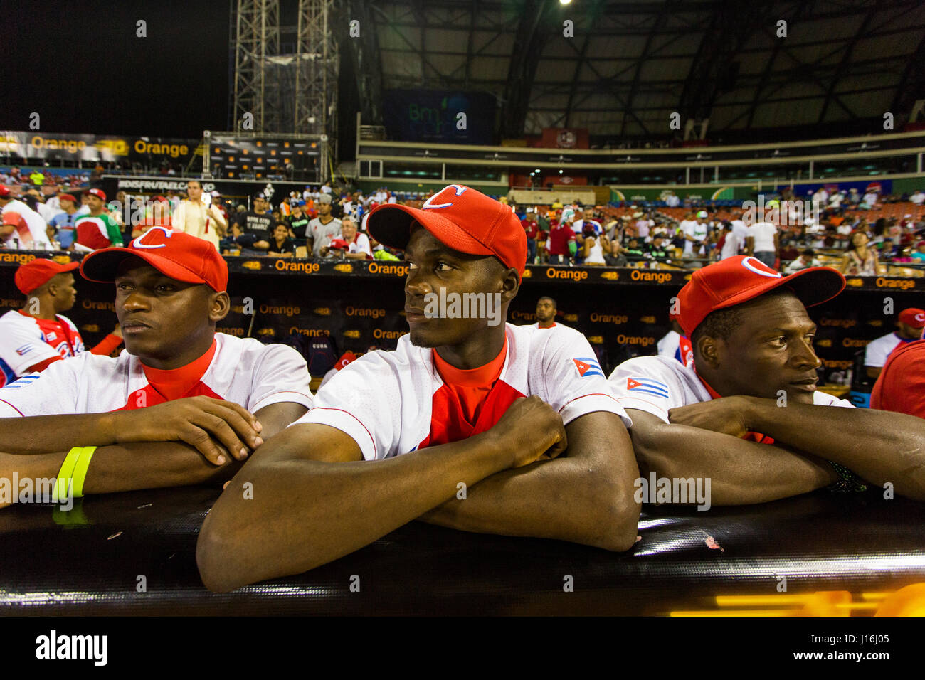 Three Cuban Baseball Players Leaning On The Dugout Fence Watching A ...