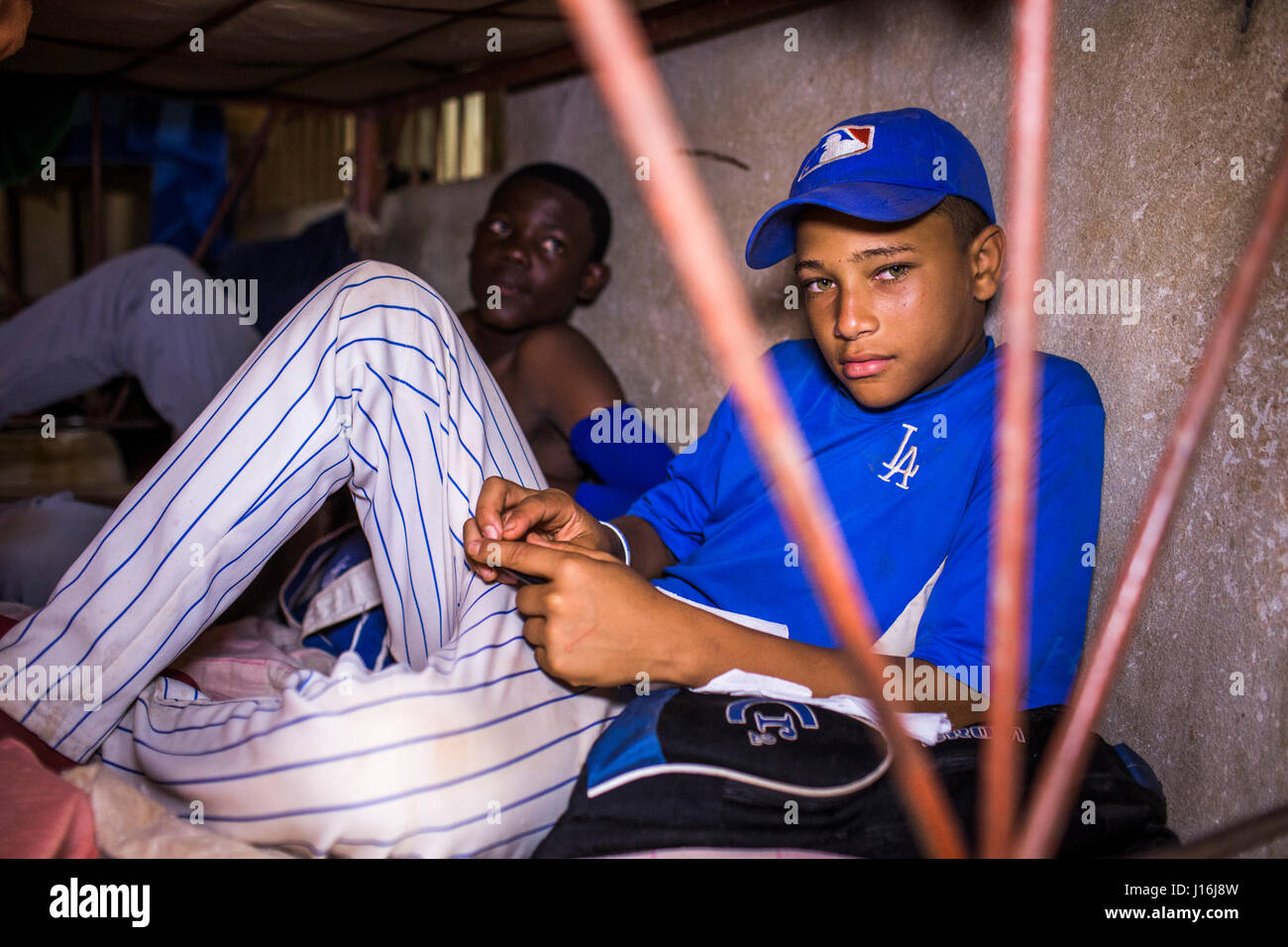Two Baseball Players In Uniform Sit On A Bunkbed Mattress In A Dark ...