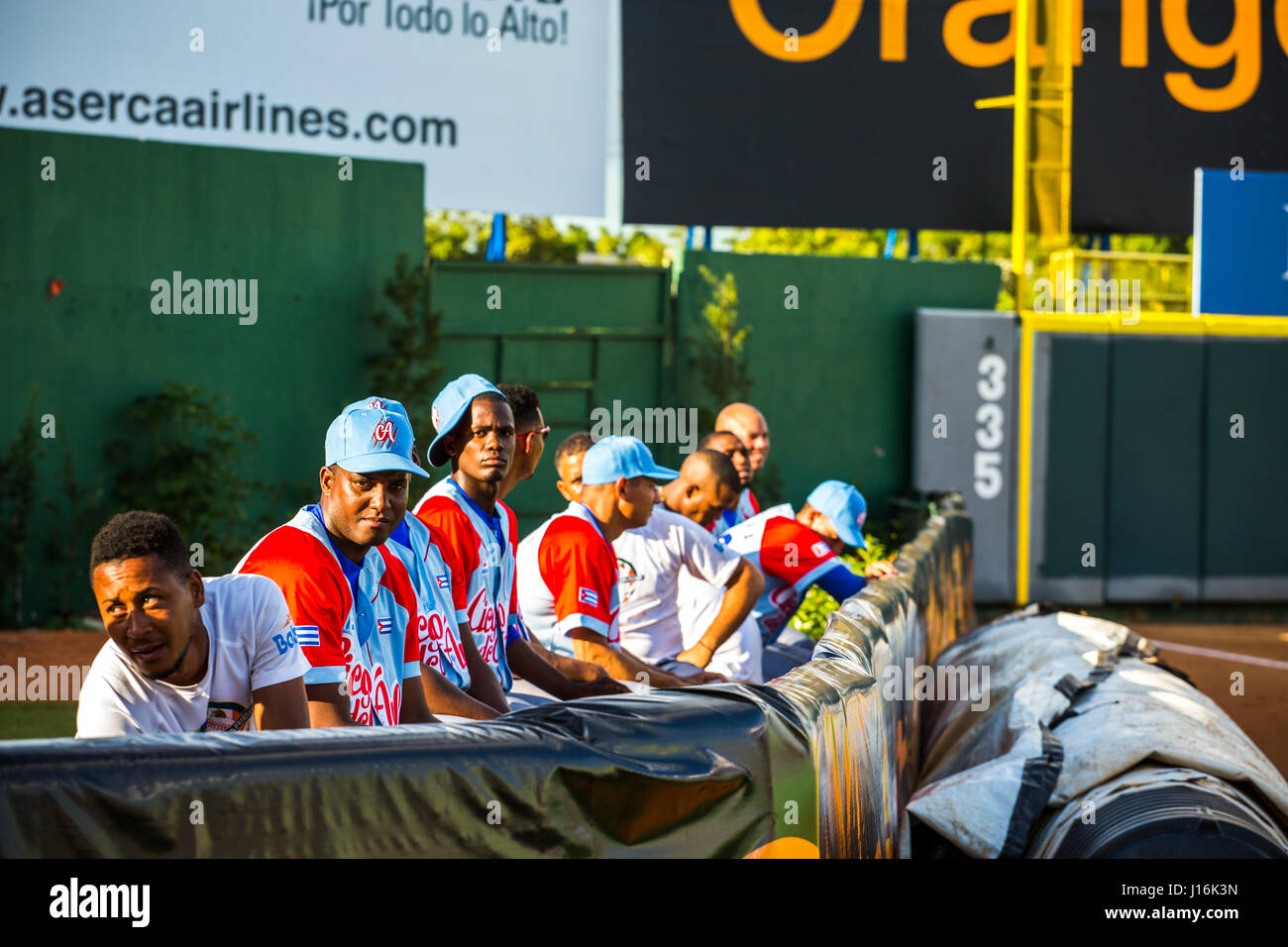 Cuban Baseball Players Standing Along The Fence Of A Baseball Field ...