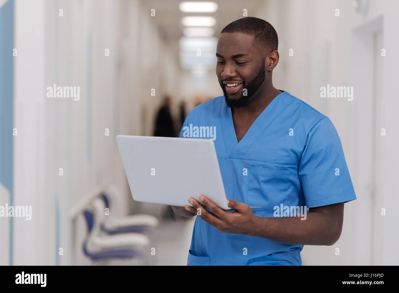 Lively African American practitioner using modern gadget in the ...