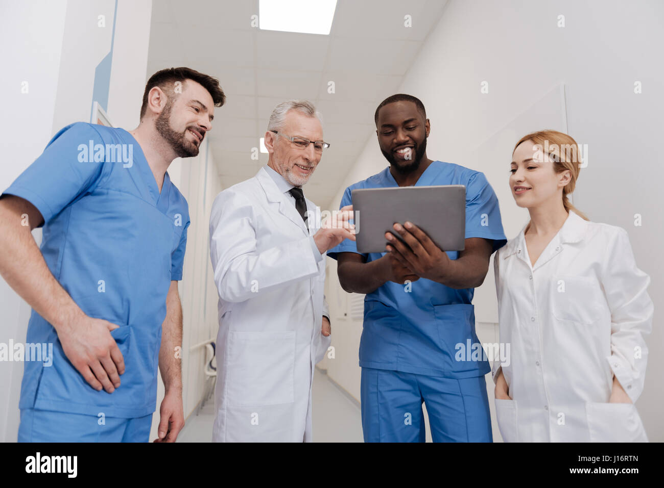 Positive medics using tablet in the hospital Stock Photo - Alamy