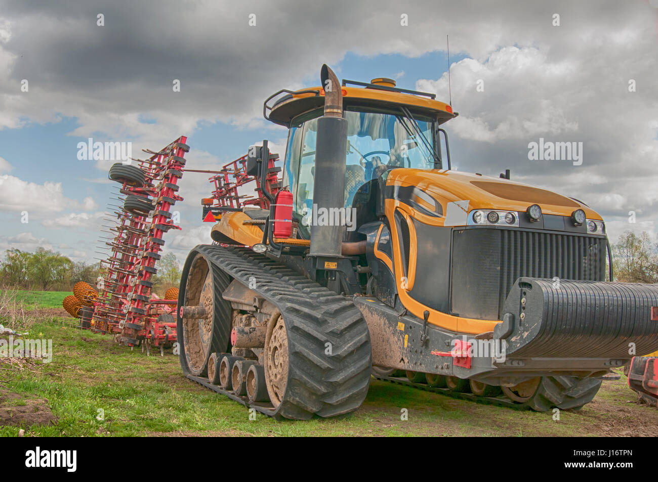 a large yellow tractor processes the field Stock Photo - Alamy