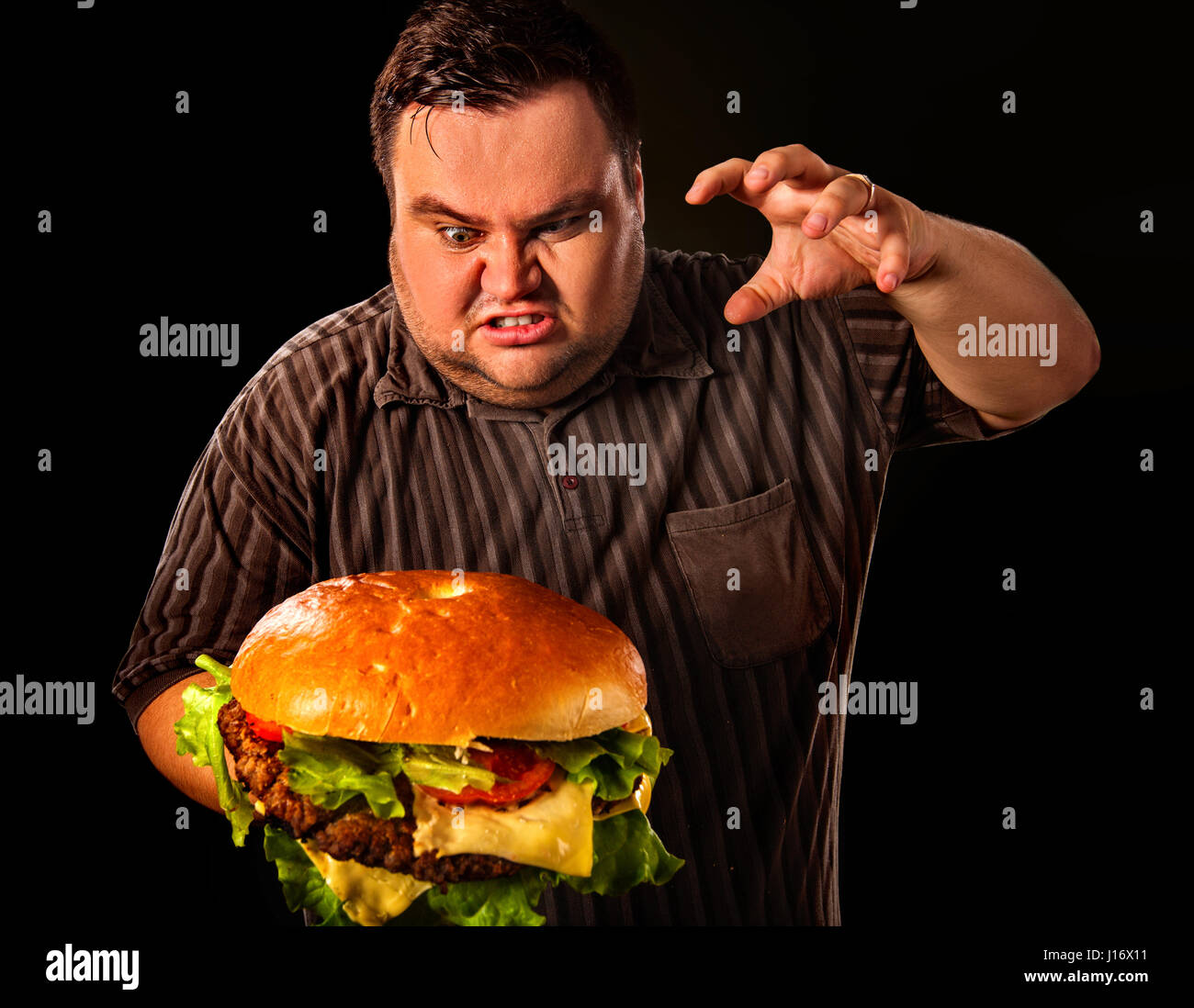Fat man eating fast food hamberger. Breakfast for overweight person ...